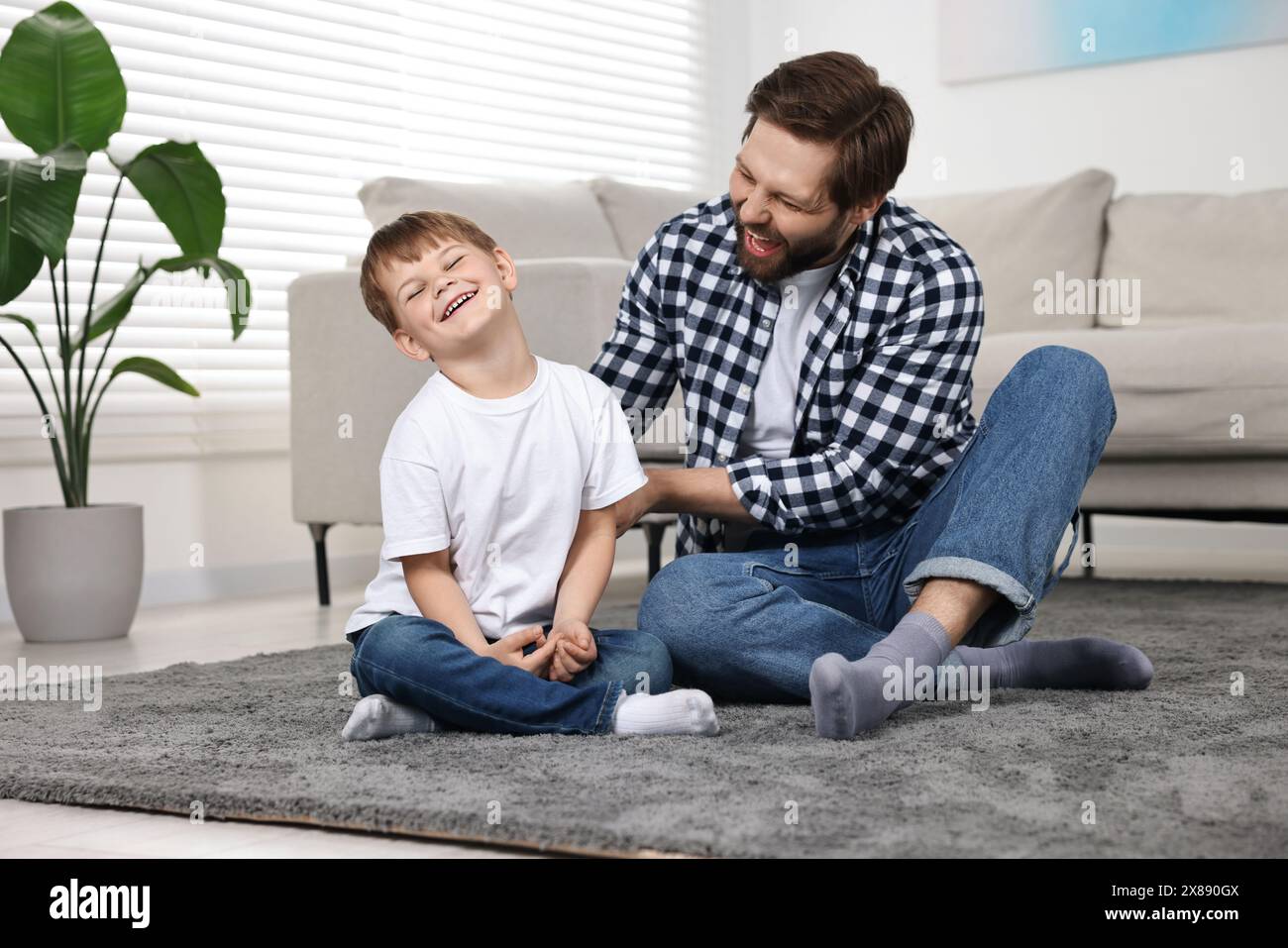 Happy dad and son having fun on carpet at home Stock Photo - Alamy