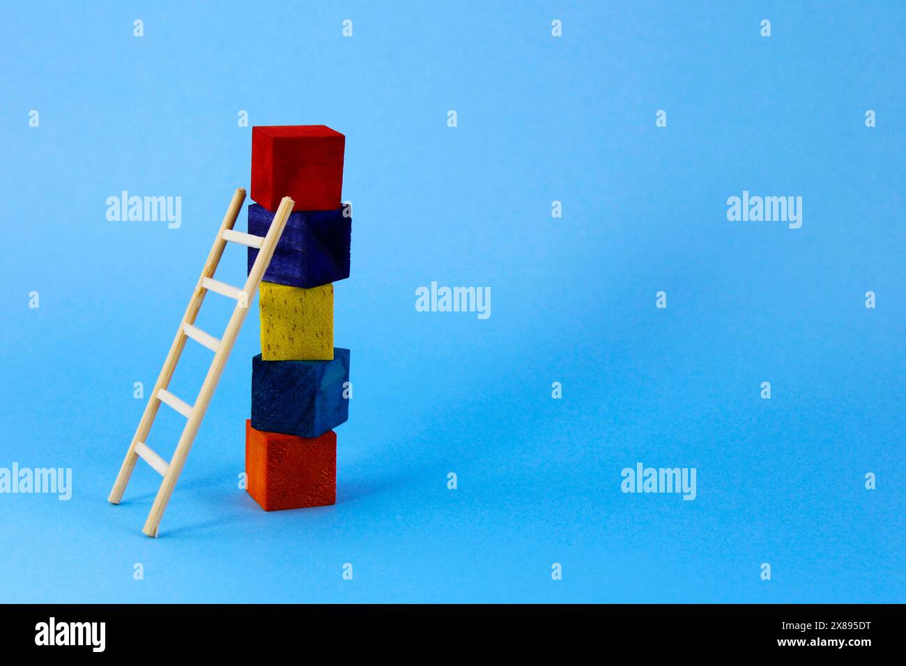 Ladder supported on column formed with cubes of different colors Stock ...