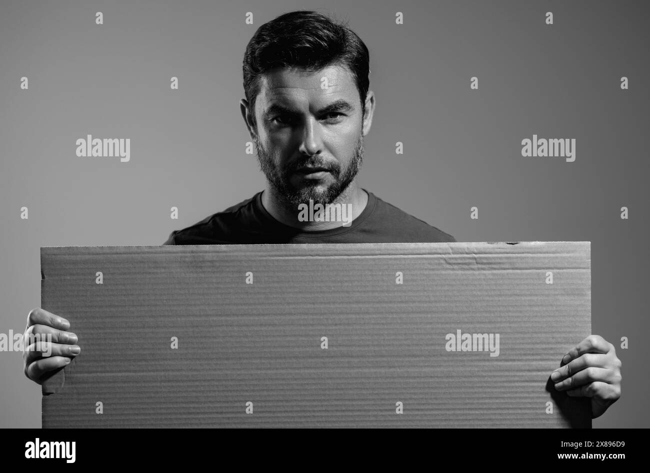 Serious man holding empty board. Successful man showing blank signboard ...