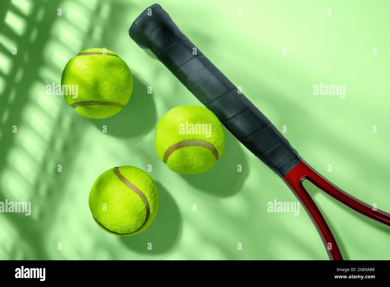 Overhead view of a tennis racket with grip and three bright yellow ...