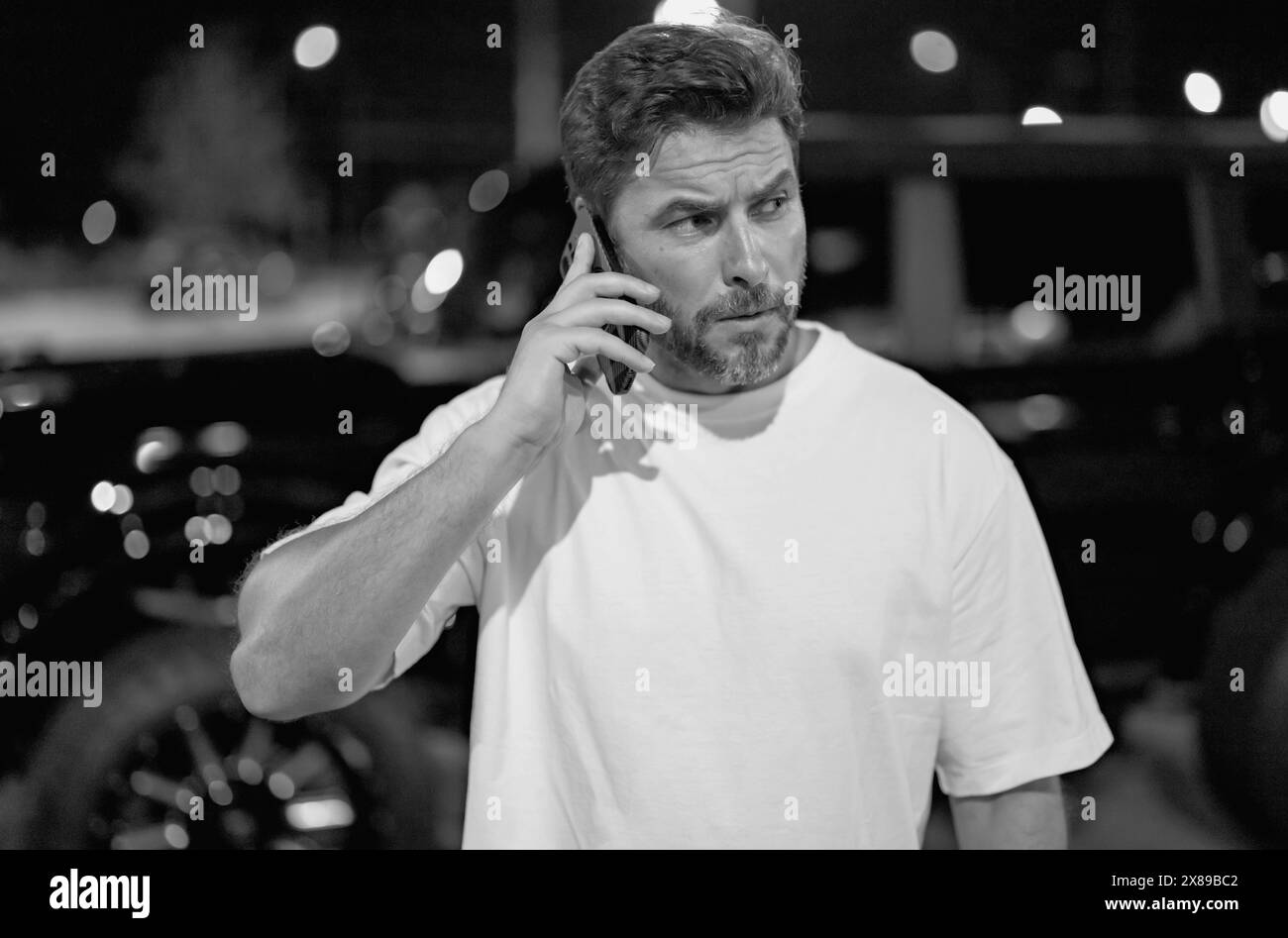 Angry man talking on phone outdoor. Angry hipster talking on phone near ...