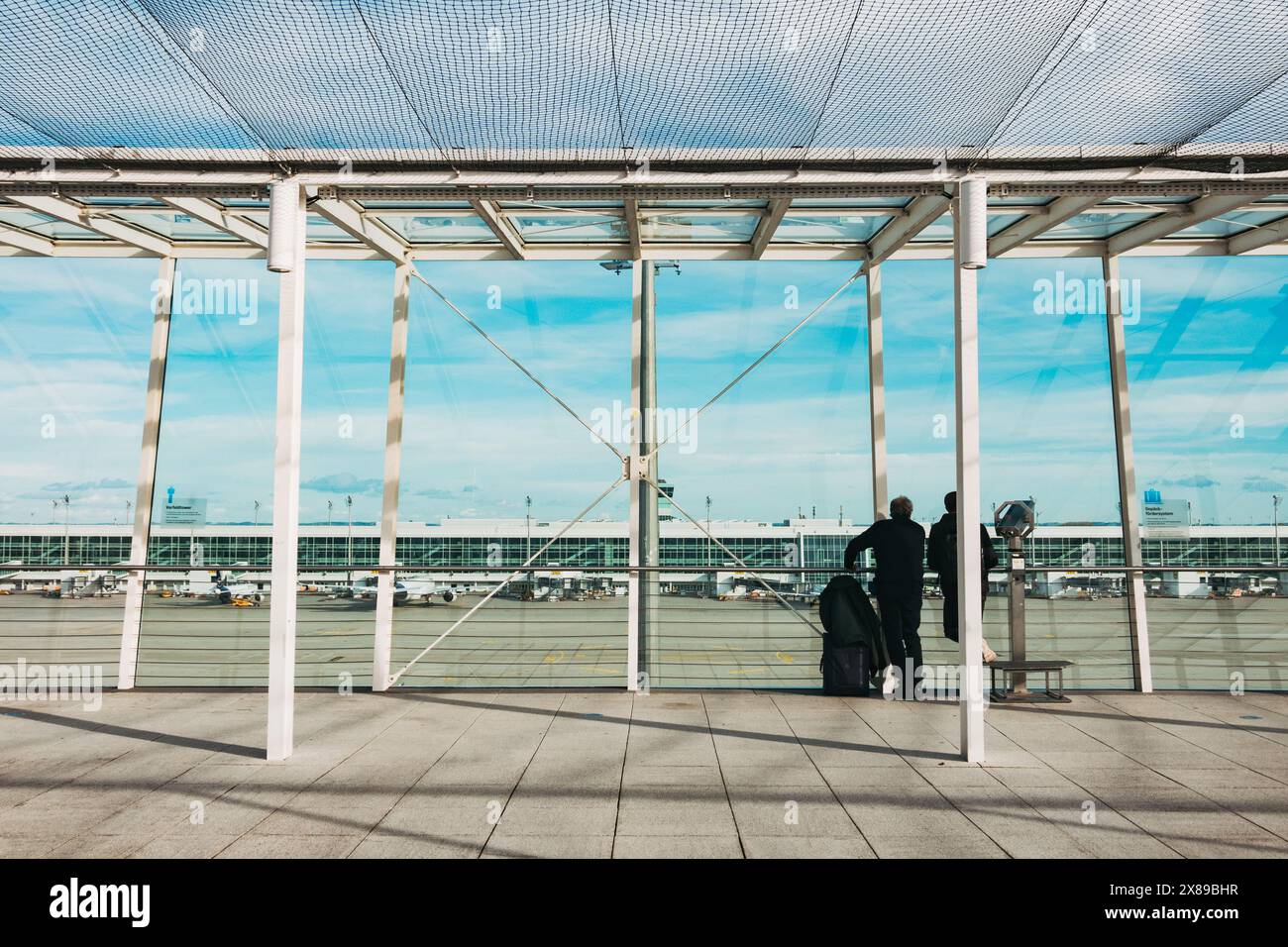 Passengers stand next to binoculars at the Terminal 2 outdoor ...