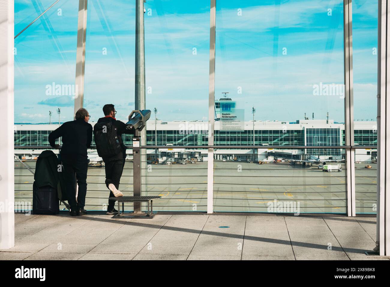 Passengers stand next to binoculars at the Terminal 2 outdoor ...