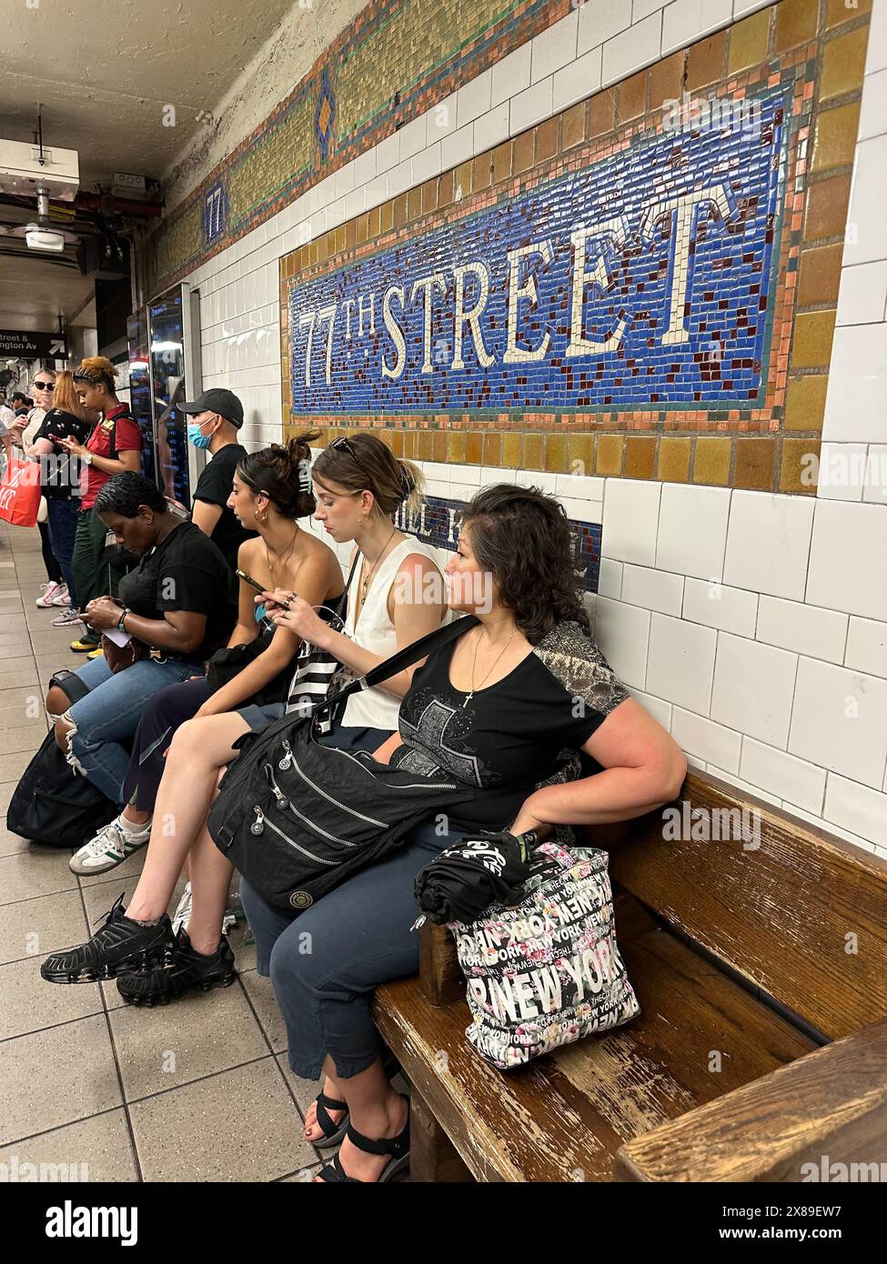 Commuters waiting for the subway at the 77th Street subway station at ...