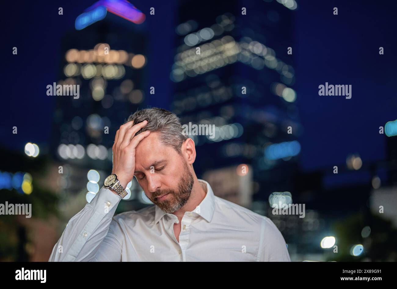 Close up portrait of stressed business man on night city background. Stressed ceo manager have ...