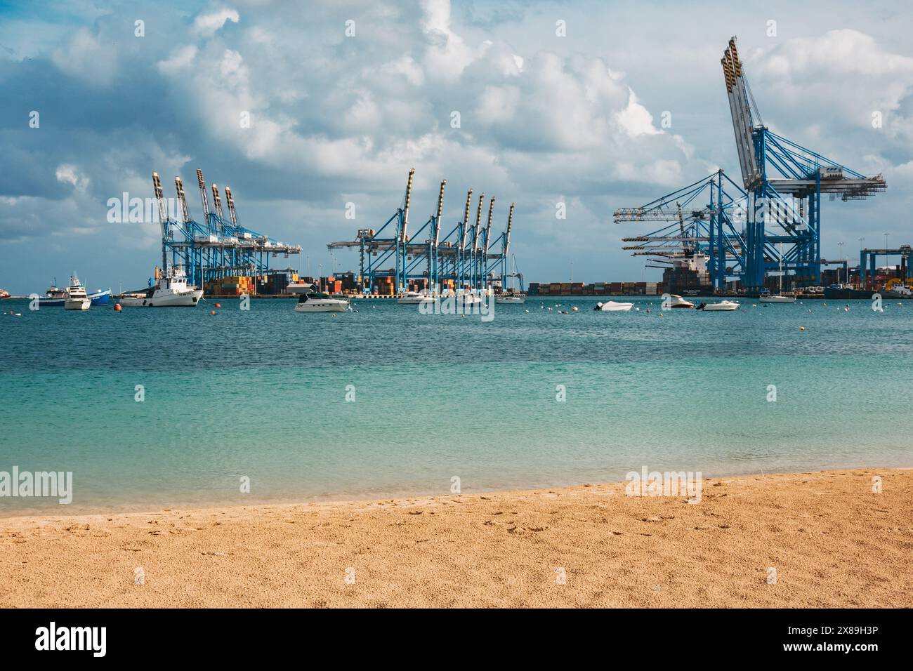 A damp beach in the coastal town of Birżebbuġa, Malta with rain clouds ...