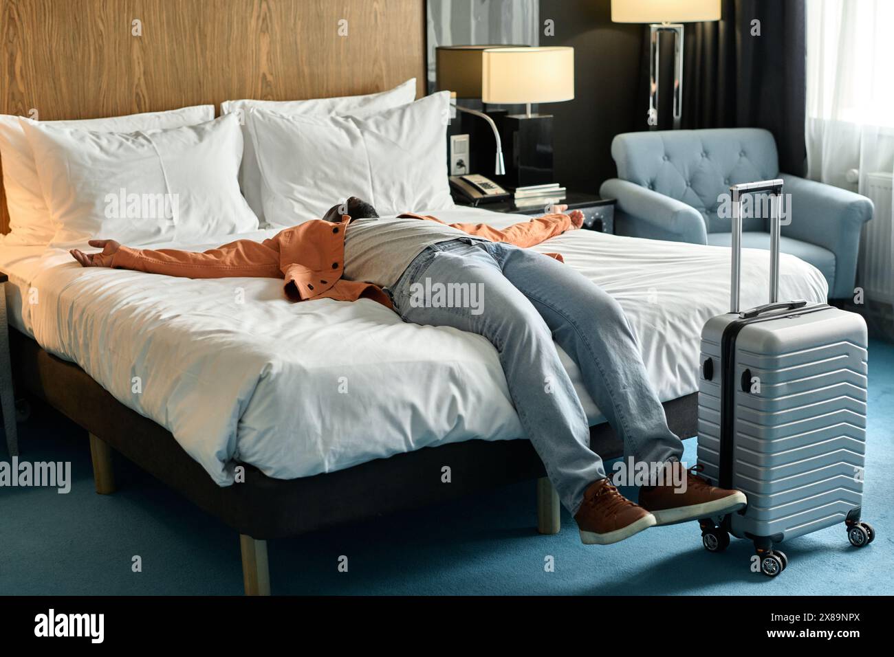 Full length shot of excited Black man falling backwards onto bed upon ...