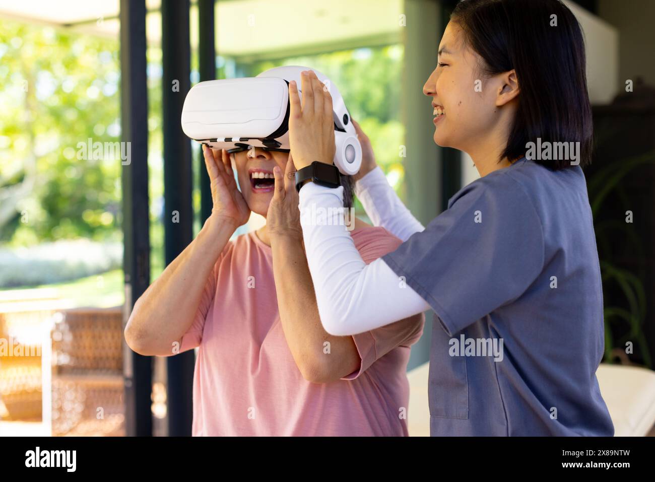 Asian nurse and middle-aged patient wear VR headsets at home, both ...