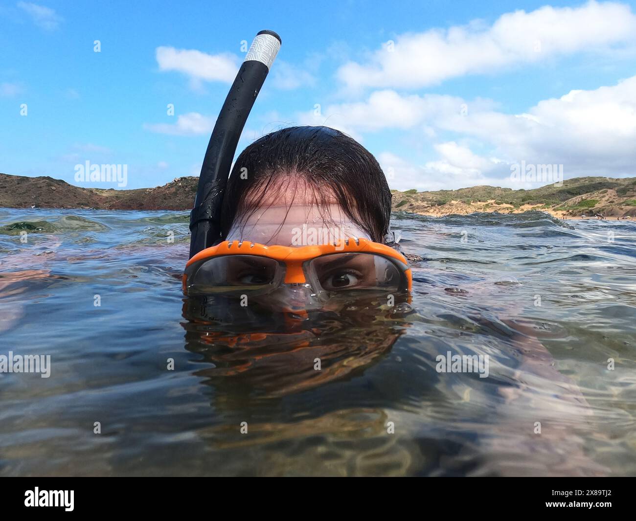 A woman's head with a diving mask and snorkel, submerged in seawater up ...