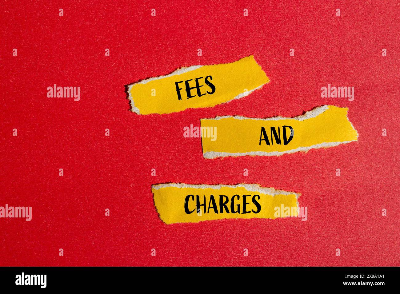 Fees and charges words written on ripped yellow paper pieces with red ...