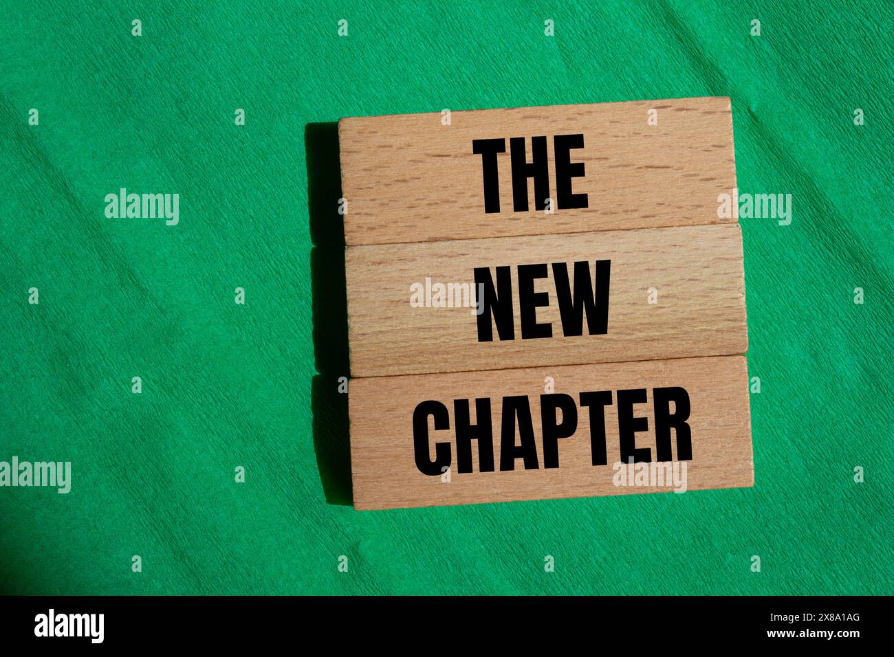 The new chapter words written on wooden blocks with green background ...