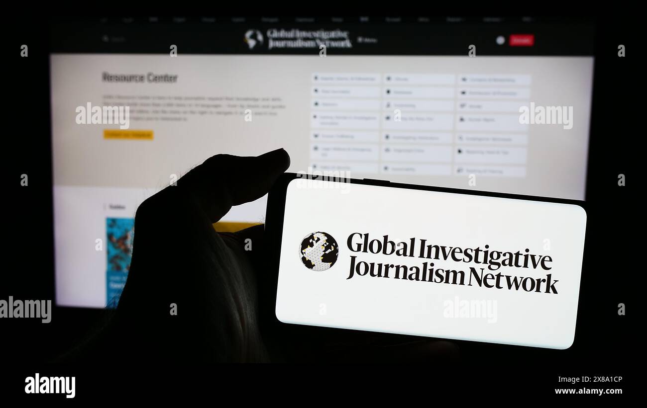 Person holding mobile phone with logo of Global Investigative ...