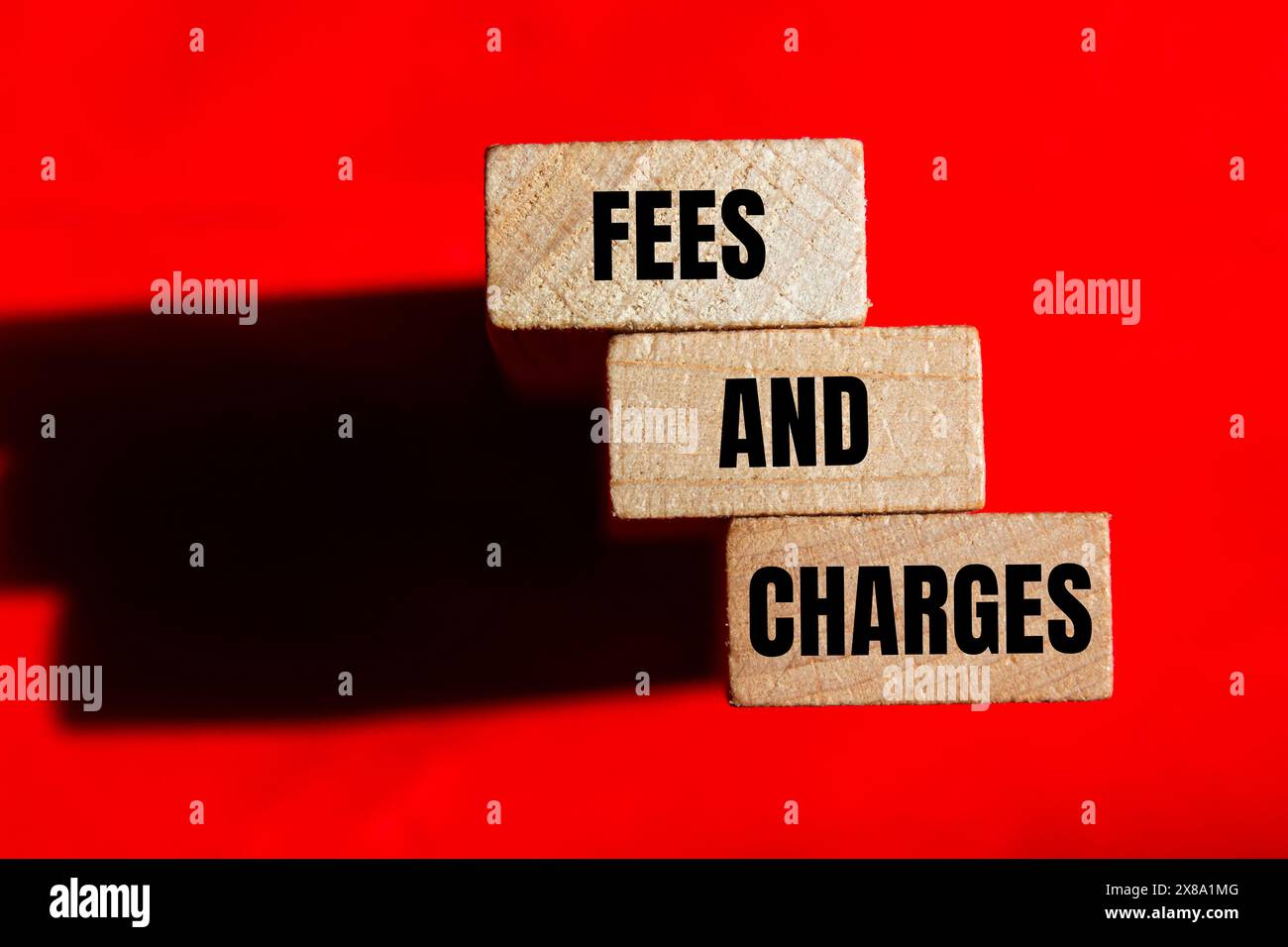 Fees and charges words written on wooden blocks with red background ...