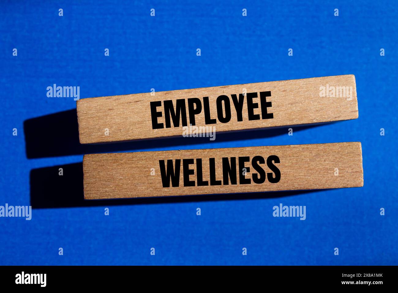 Employee wellness words written on wooden blocks with blue background ...