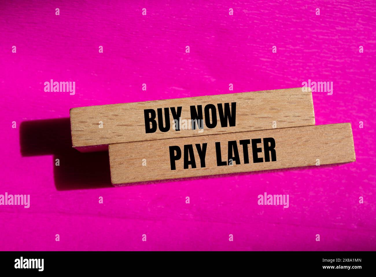 Buy now pay later words written on wooden blocks with pink background ...