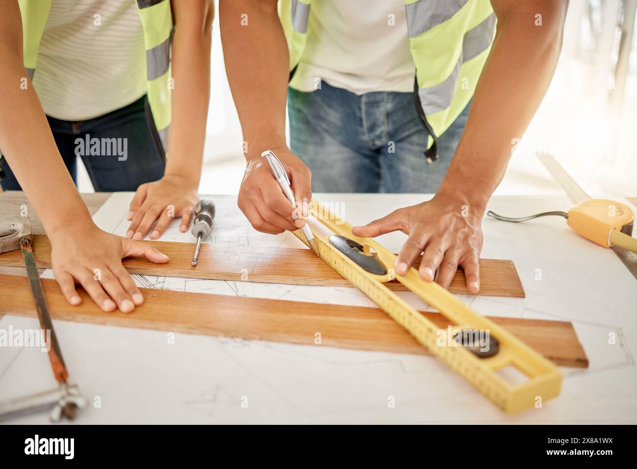 Hands, handyman and plank on table with tape for measurement, accuracy ...