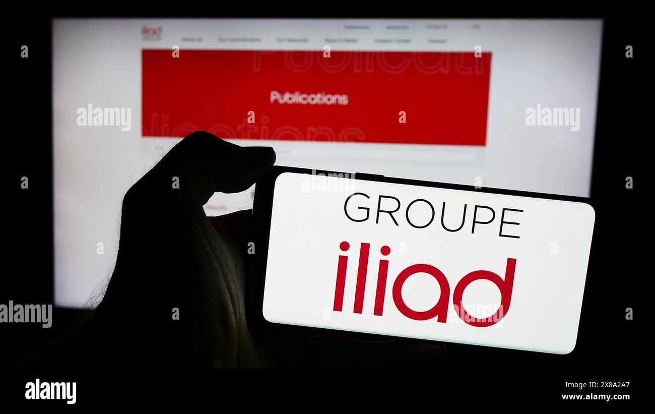 Person holding mobile phone with logo of French telecommunications ...