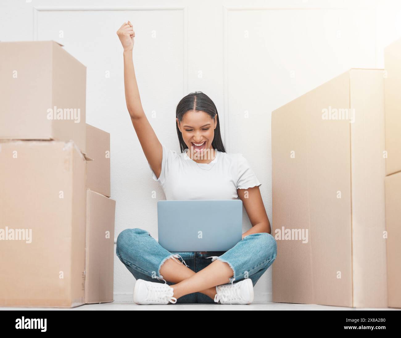 Laptop, moving or woman packing with fist up and boxes in new home for ...