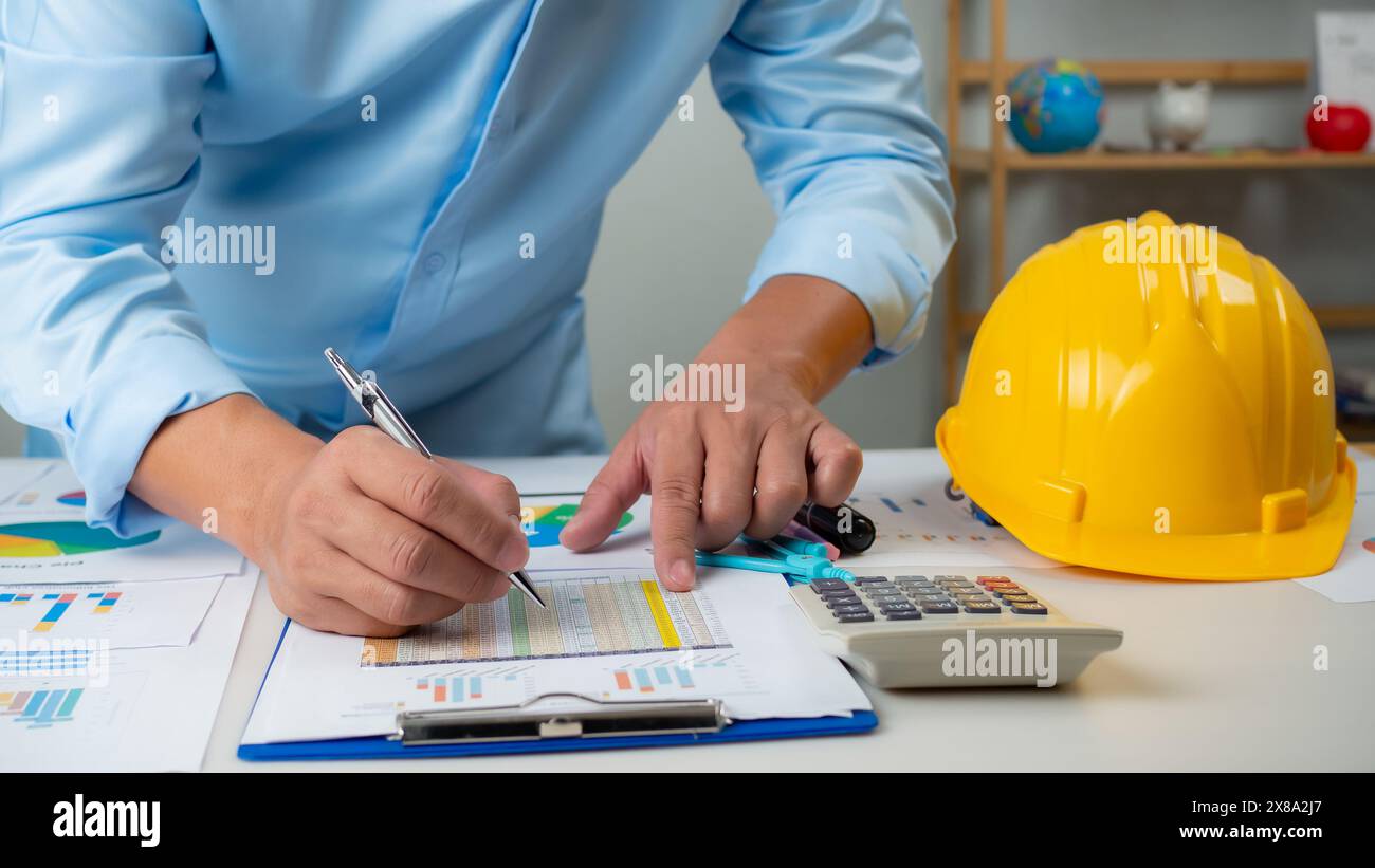 Architect or engineer sitting at desk in office, Cost calculation ...