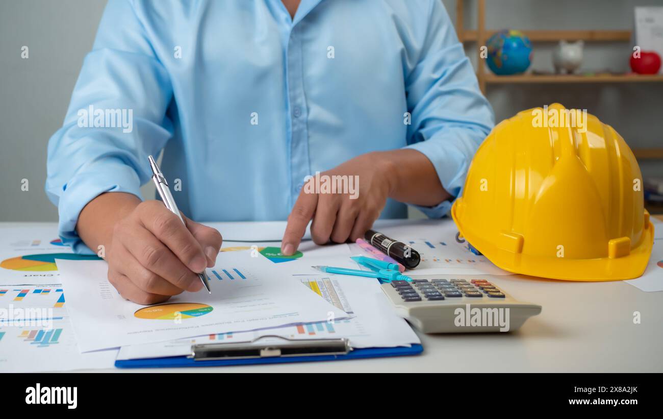 Architect or engineer sitting at desk in office, Cost calculation ...