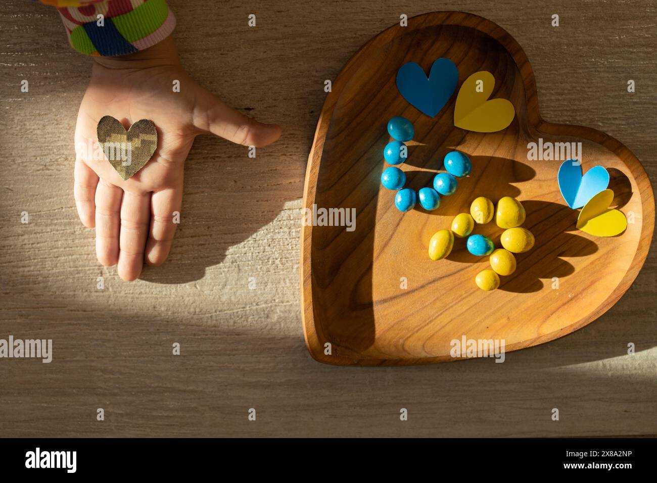 heart cut out of military camouflage fabric and yellow and blue letters ...