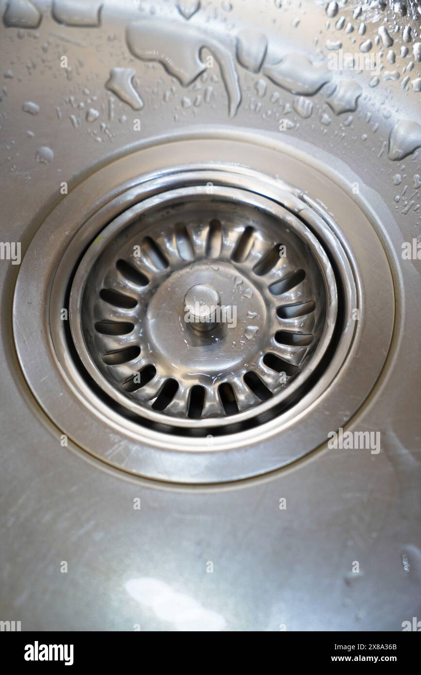 Stainless steel sink and water drain in a modern kitchen, water flow in ...