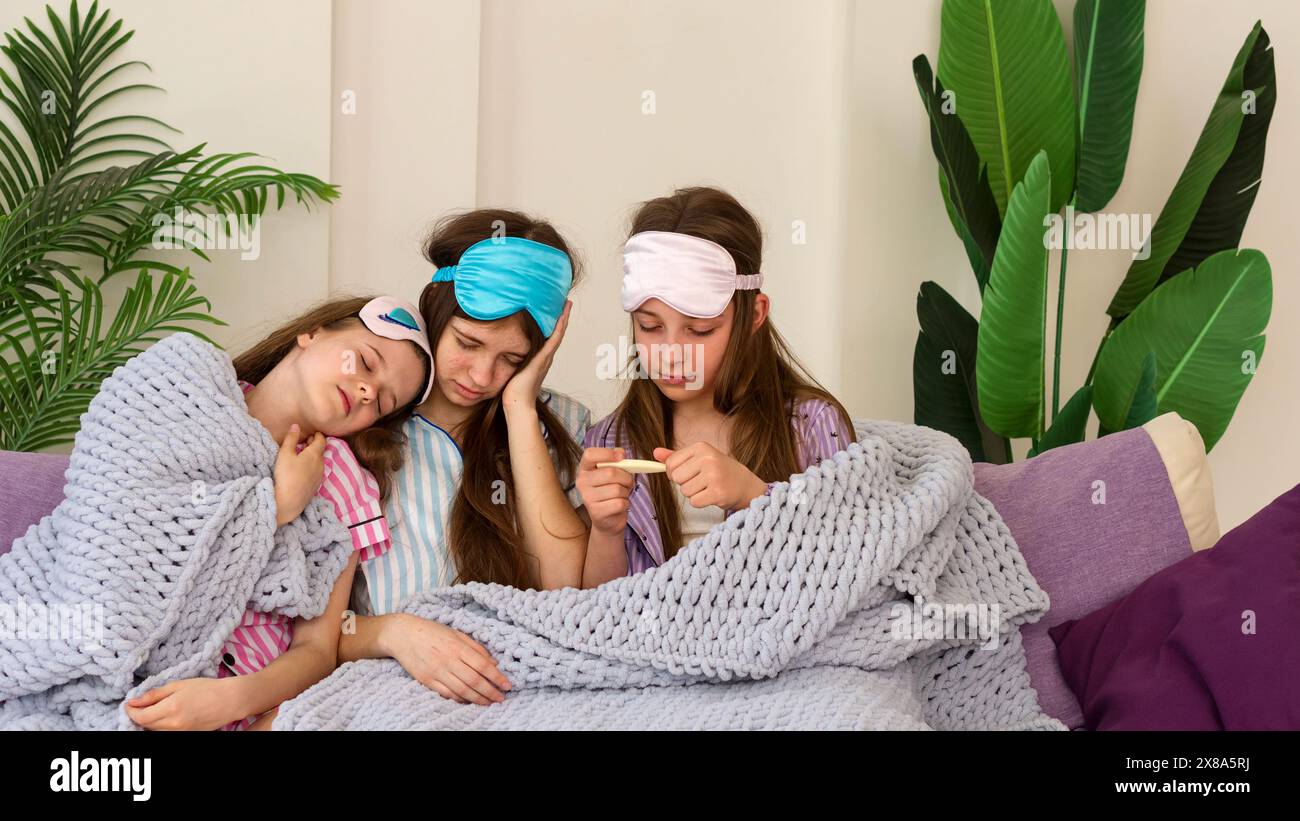 Three sick girls asleep on couch with blankets. Sisters are dressed in ...
