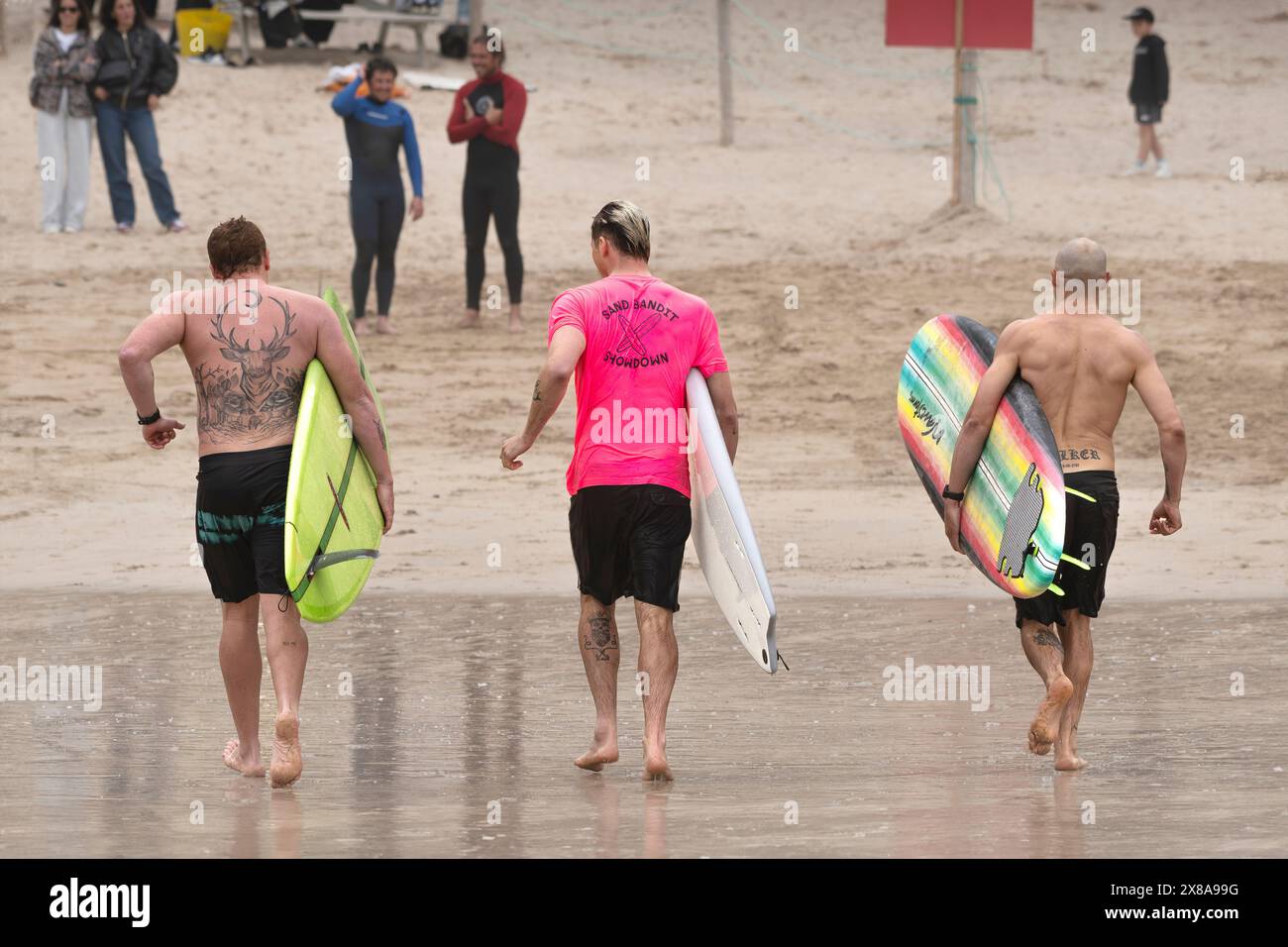 Surfers running out of the sea after competing in the Sand Bandit ...