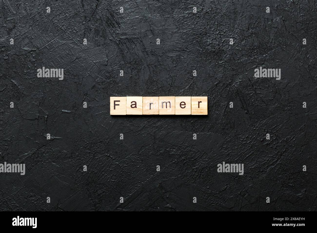 FARMER word written on wood block. FARMER text on cement table for your ...