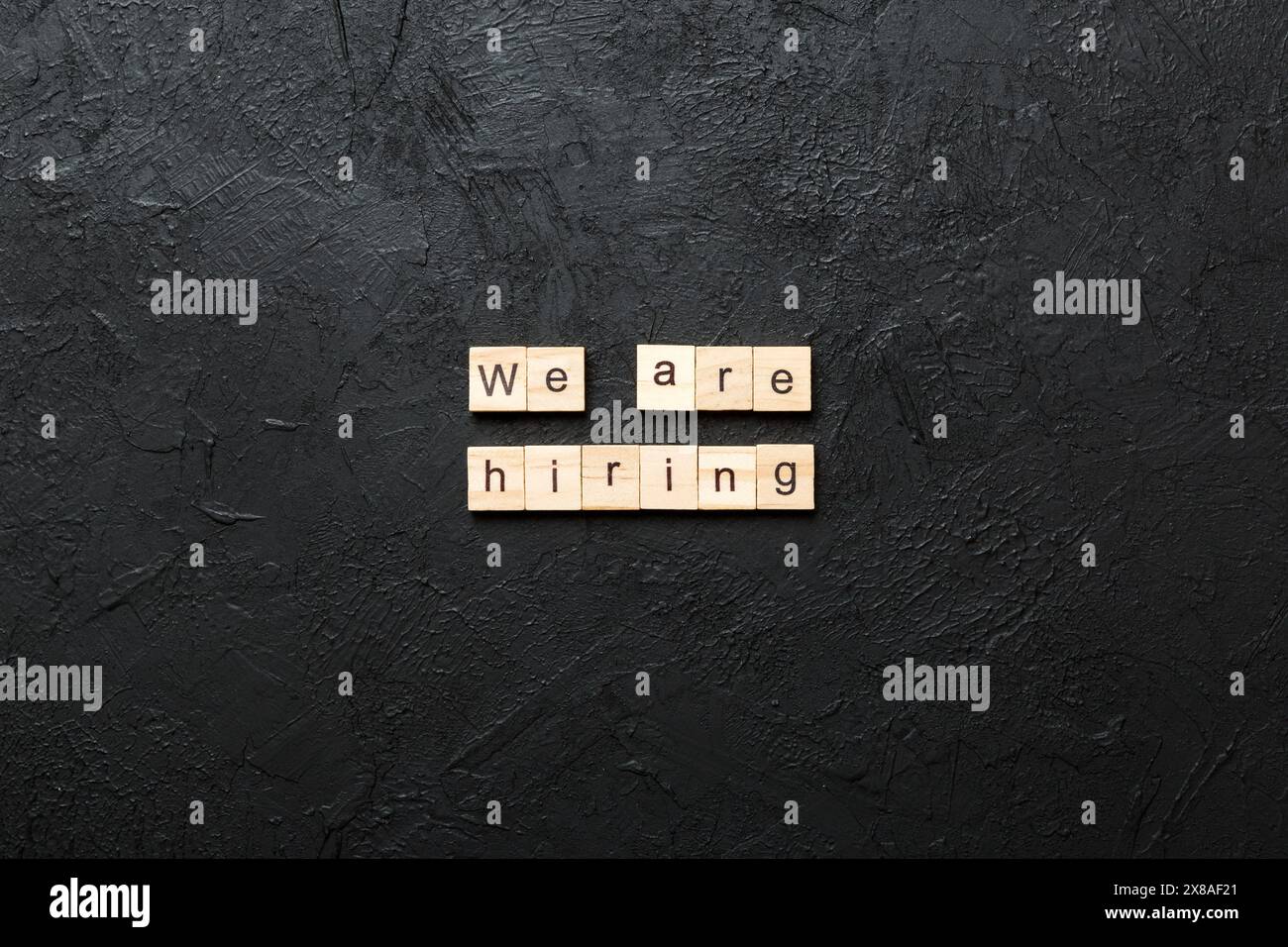 We are hiring word written on wood block. We are hiring text on cement ...
