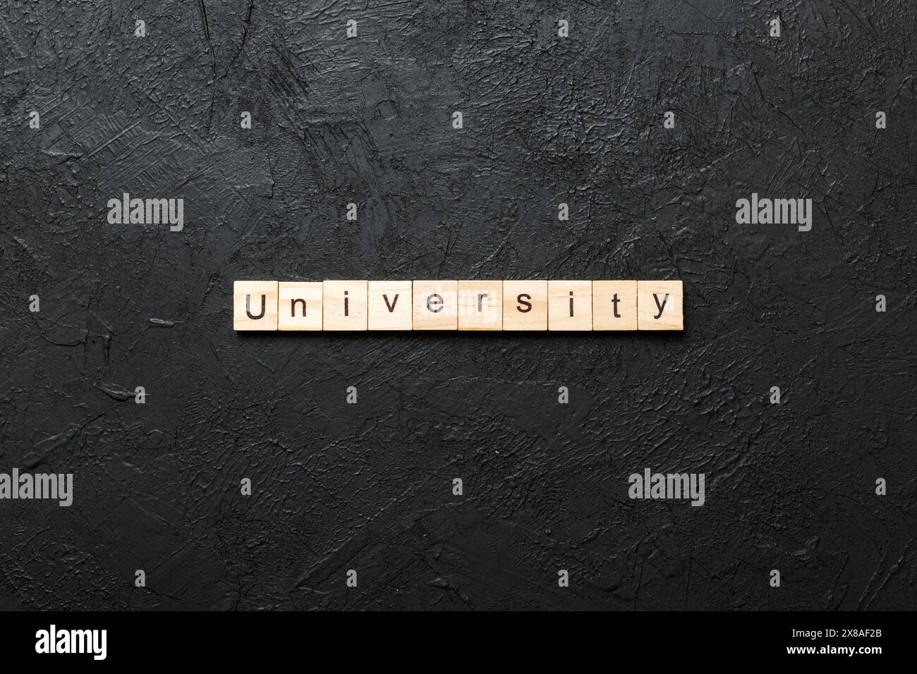 UNIVERSITY word written on wood block. UNIVERSITY text on cement table ...