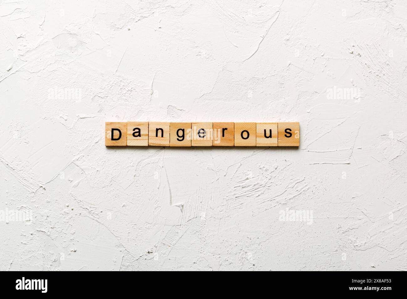 dangerous word written on wood block. dangerous text on cement table ...