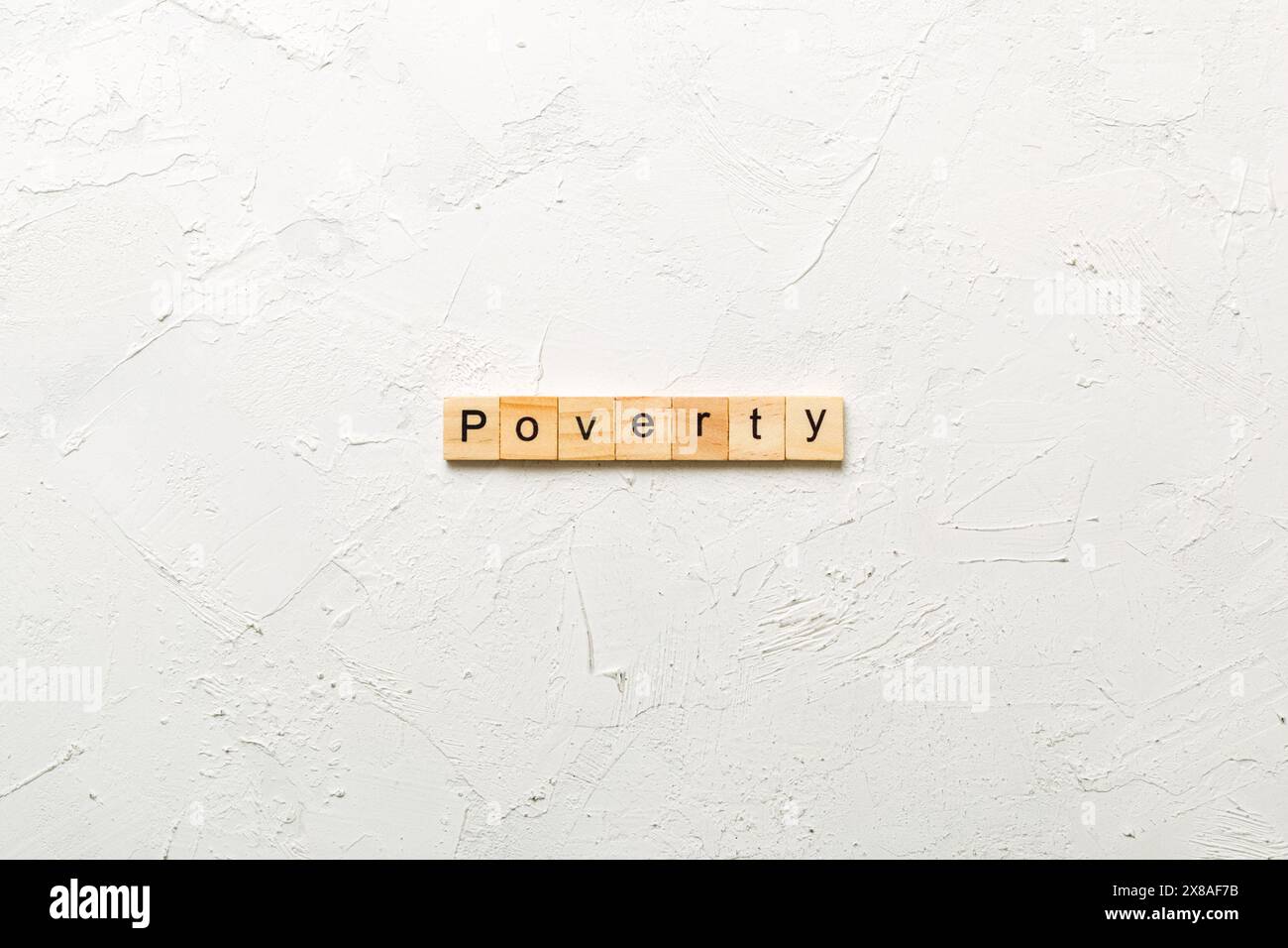 Poverty word written on wood block. Poverty text on cement table for ...
