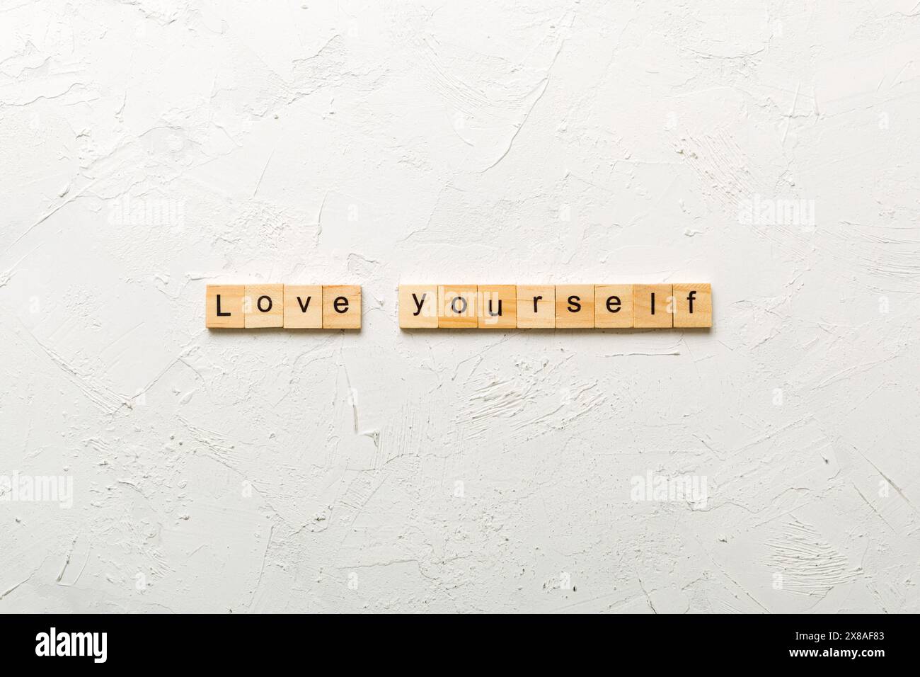 Love yourself word written on wood block. Love yourself text on cement ...