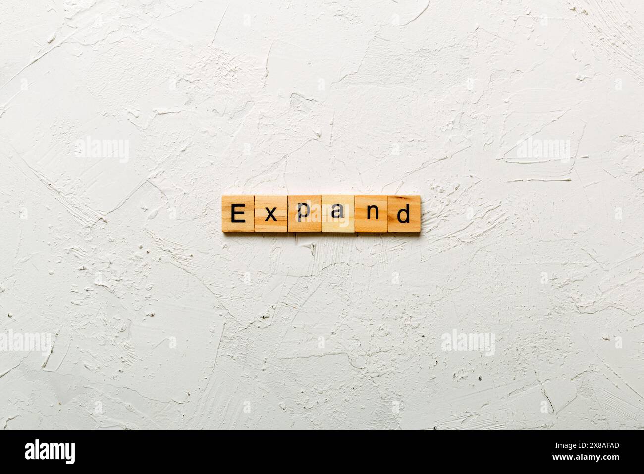 EXPAND word written on wood block. EXPAND text on cement table for your ...