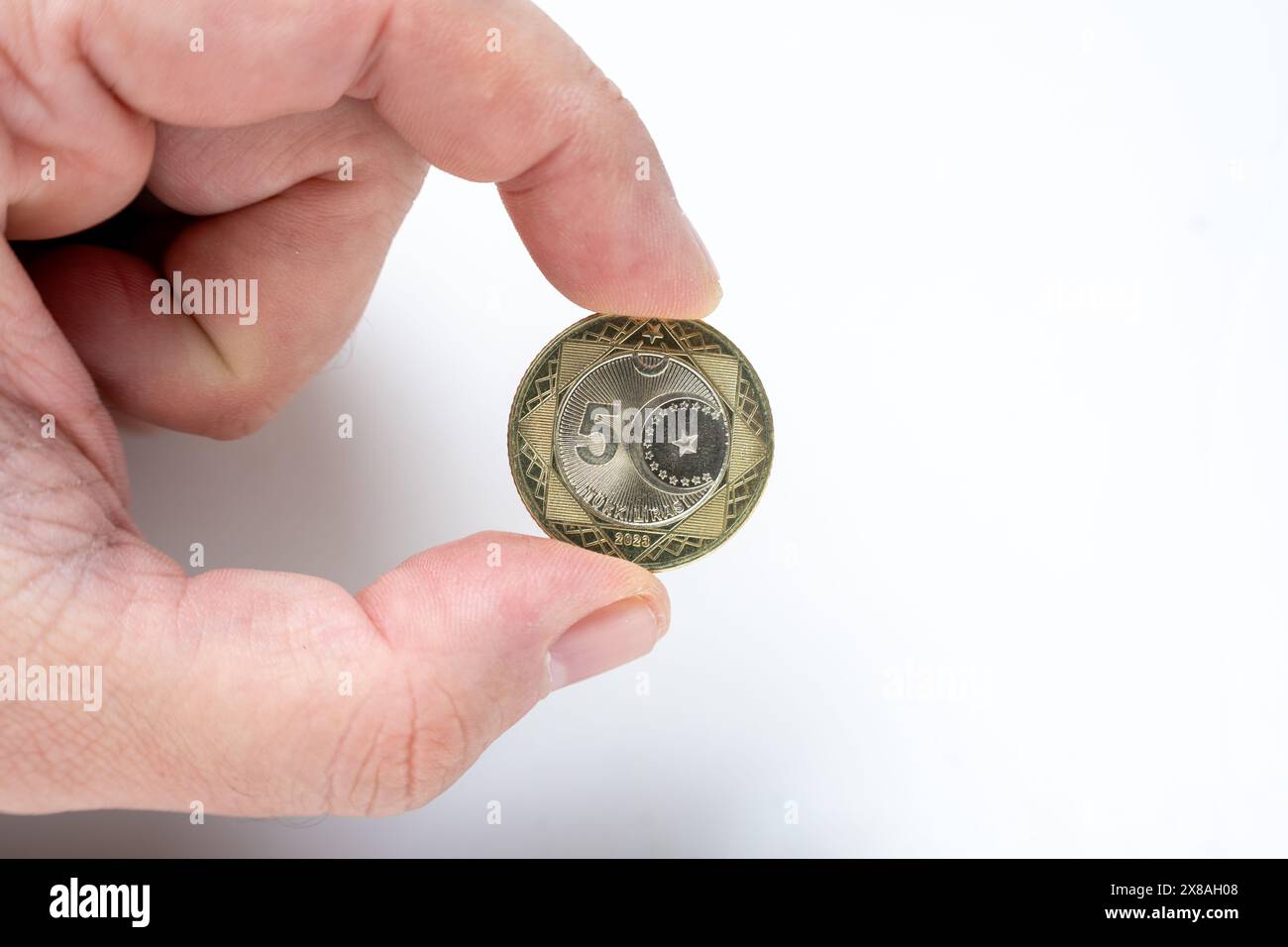 Holding new metal five turkish lira on white background Stock Photo - Alamy