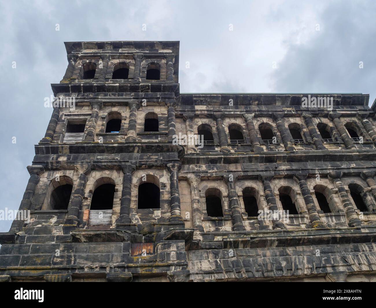 An old, impressive stone structure under a grey sky, ancient city gate ...
