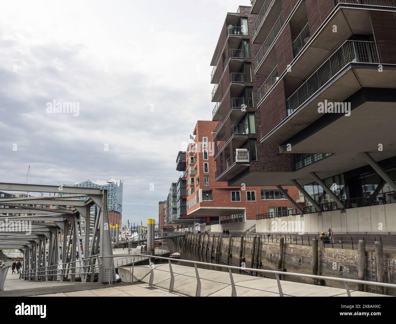 Modern office buildings along a pedestrian walkway under a cloudy sky ...