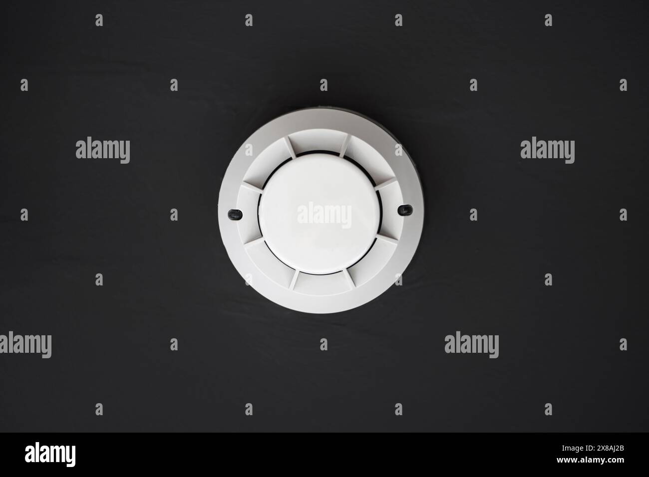 Fire and smoke detector visible from below on black ceiling Stock Photo ...