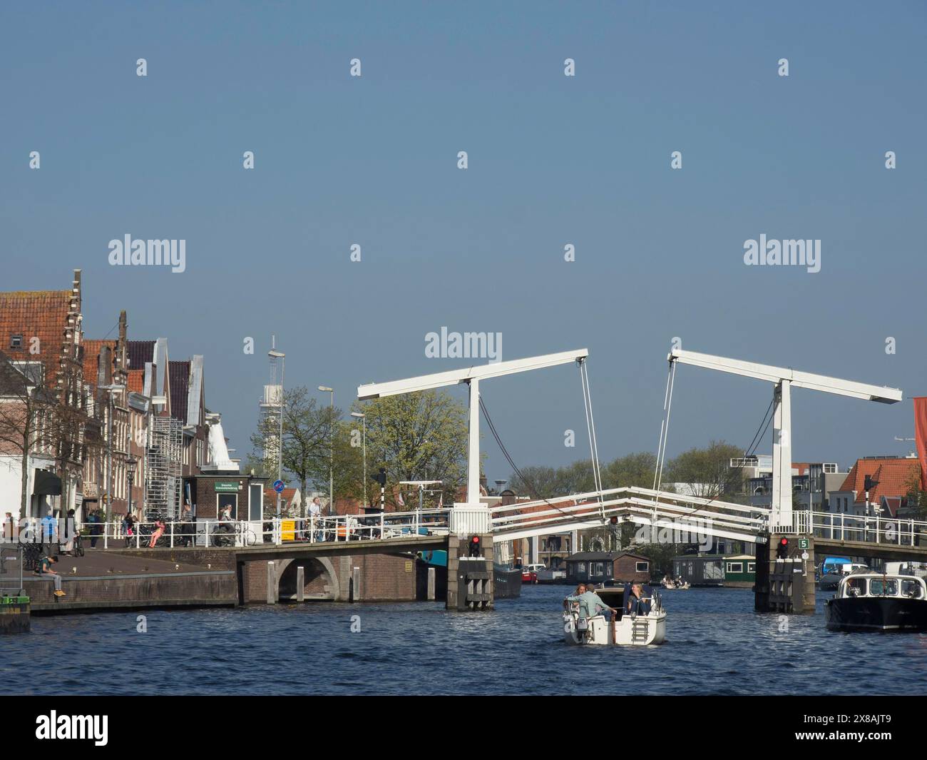 A white bridge over a river with boats surrounded by historic buildings ...