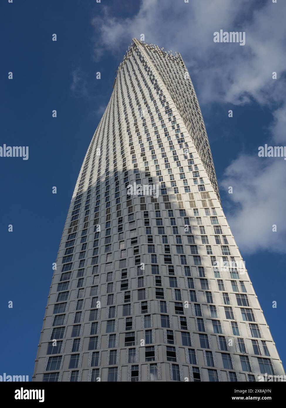 Modern, twisted high-rise architecture against a clear blue sky with ...