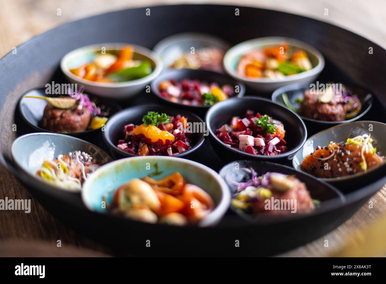 Assorted appetizers in small bowls on a rustic platter Stock Photo - Alamy