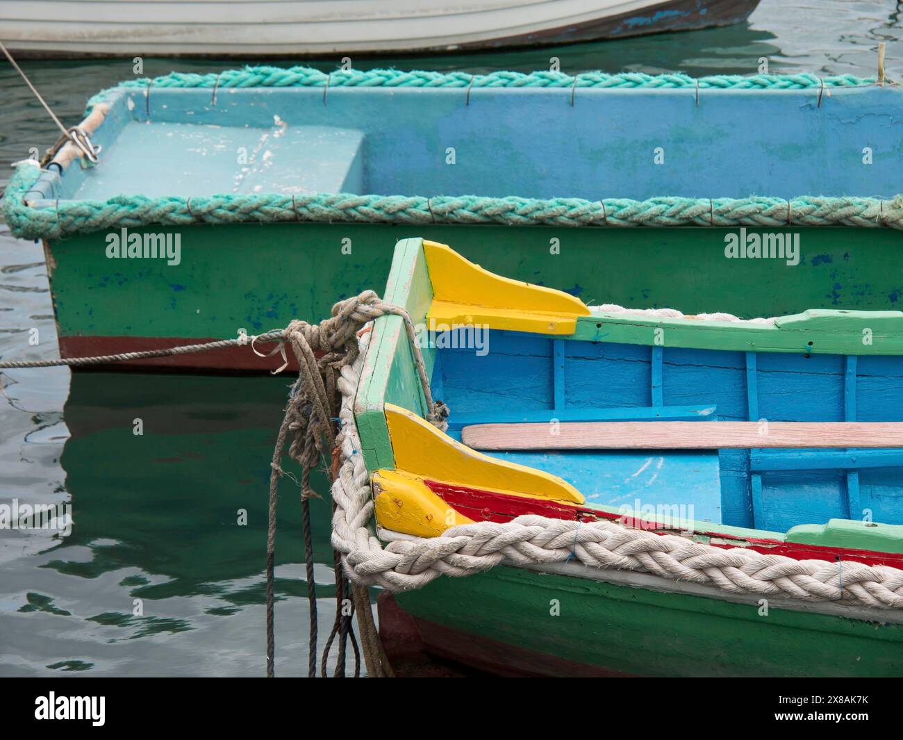 Close-up of colourful, still lying boats on water surface, small, colourful fishing boats in a ...