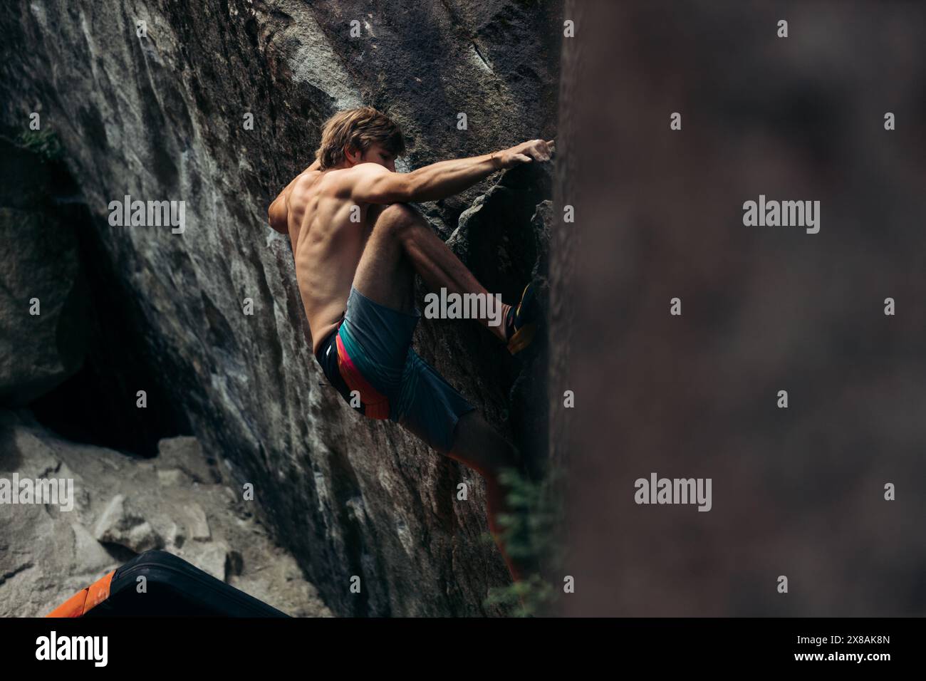 Muscular climber on a boulder in Magic Wood, Switzerland Stock Photo ...