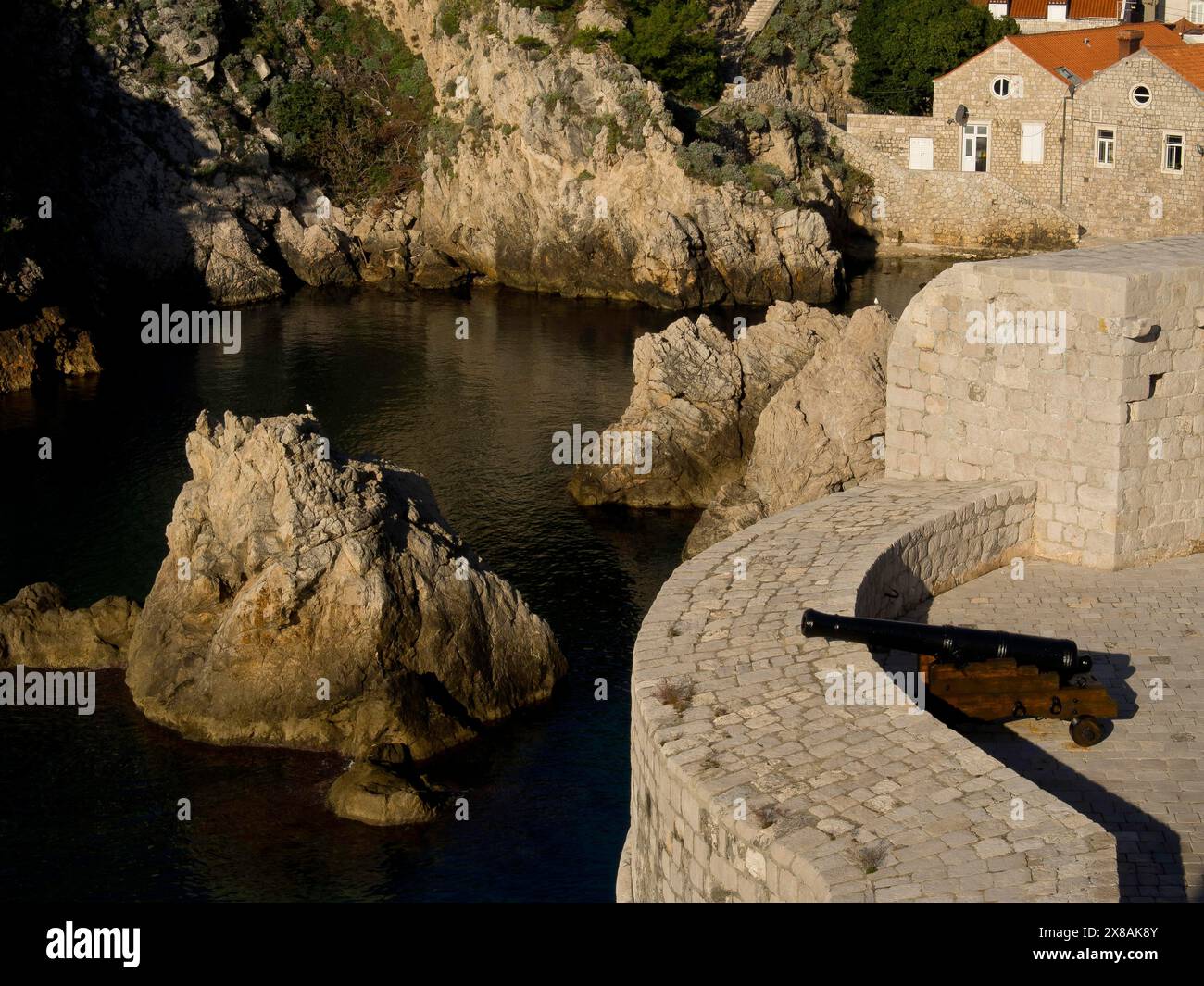 Canon on a fortress wall overlooking the sea and rocky coast, medieval ...