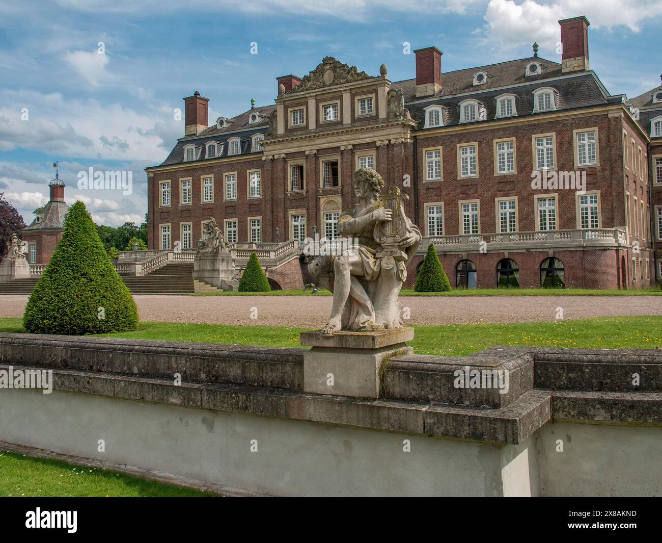 Stone statue in the foreground of a magnificent historic castle with ...