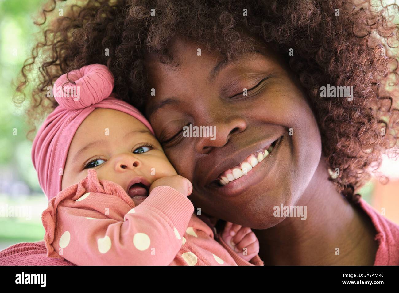African woman hugging a baby girl in a park Stock Photo - Alamy
