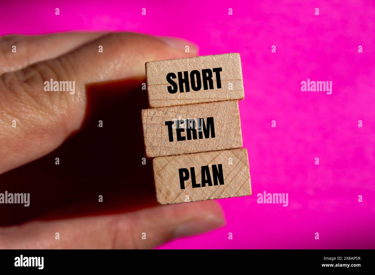 Short term plan words written on wooden blocks with pink background ...