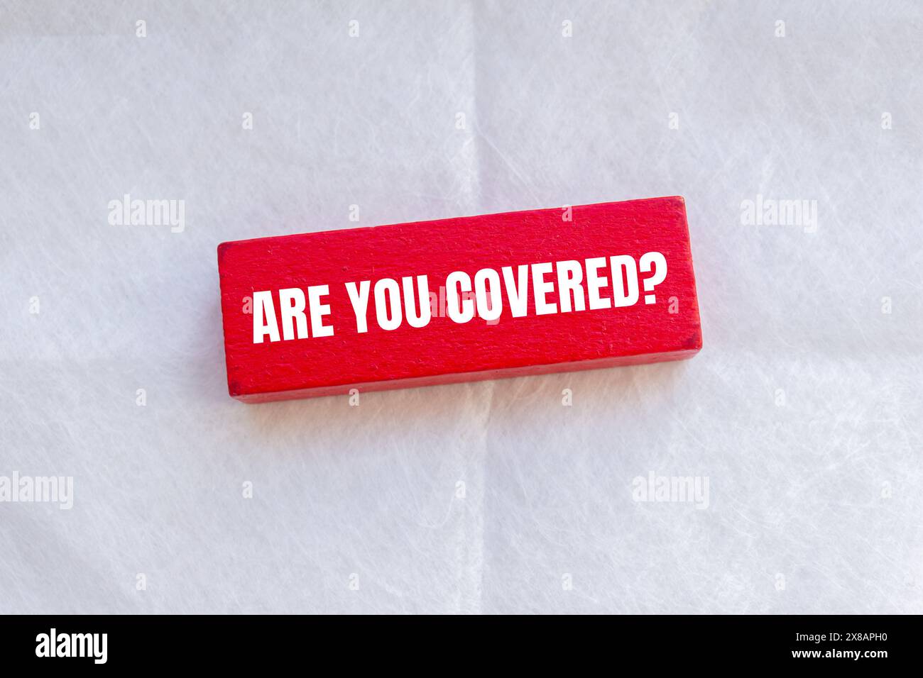 Are you covered ? words written on red wodoen block with white ...