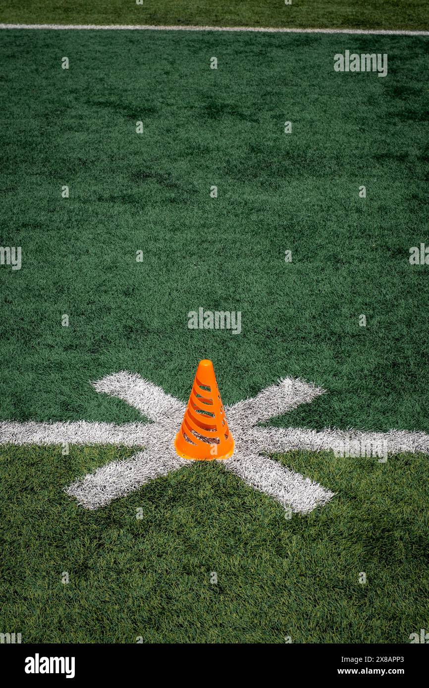 An orange athletic cone on a turf football field Stock Photo - Alamy